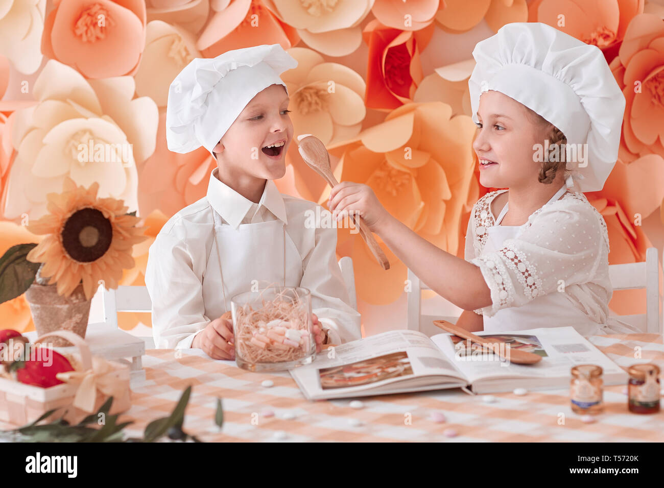 brother and sister in a chef uniform standing near the kitchen table ...