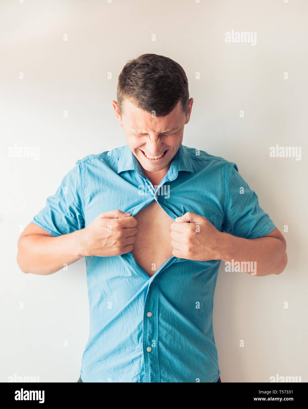 Businessman tearing off his shirt and showing mucular body concept on ...