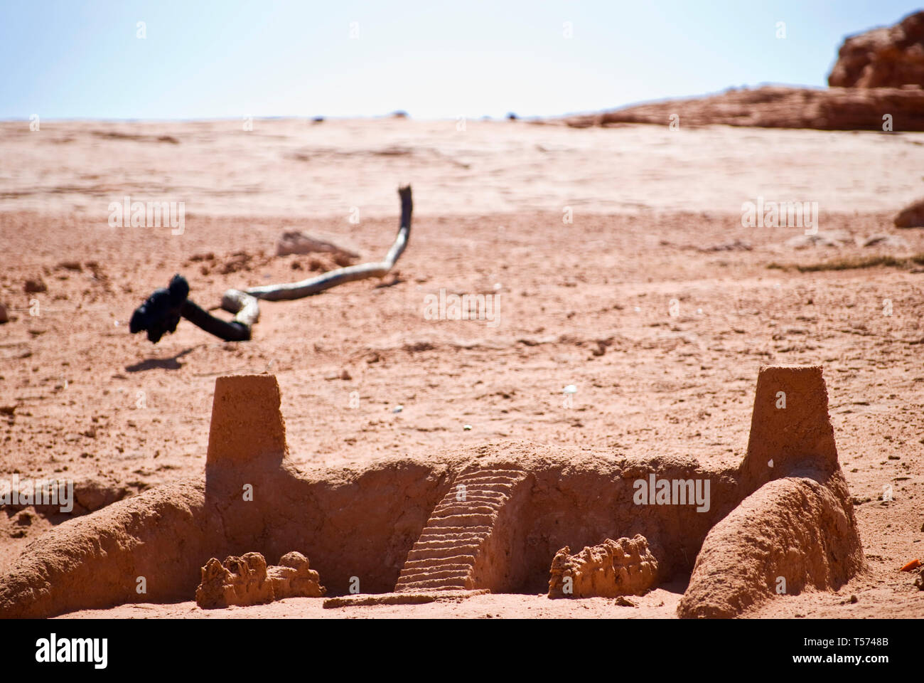 Small sand castle by the lake casting sunset shadows Stock Photo - Alamy