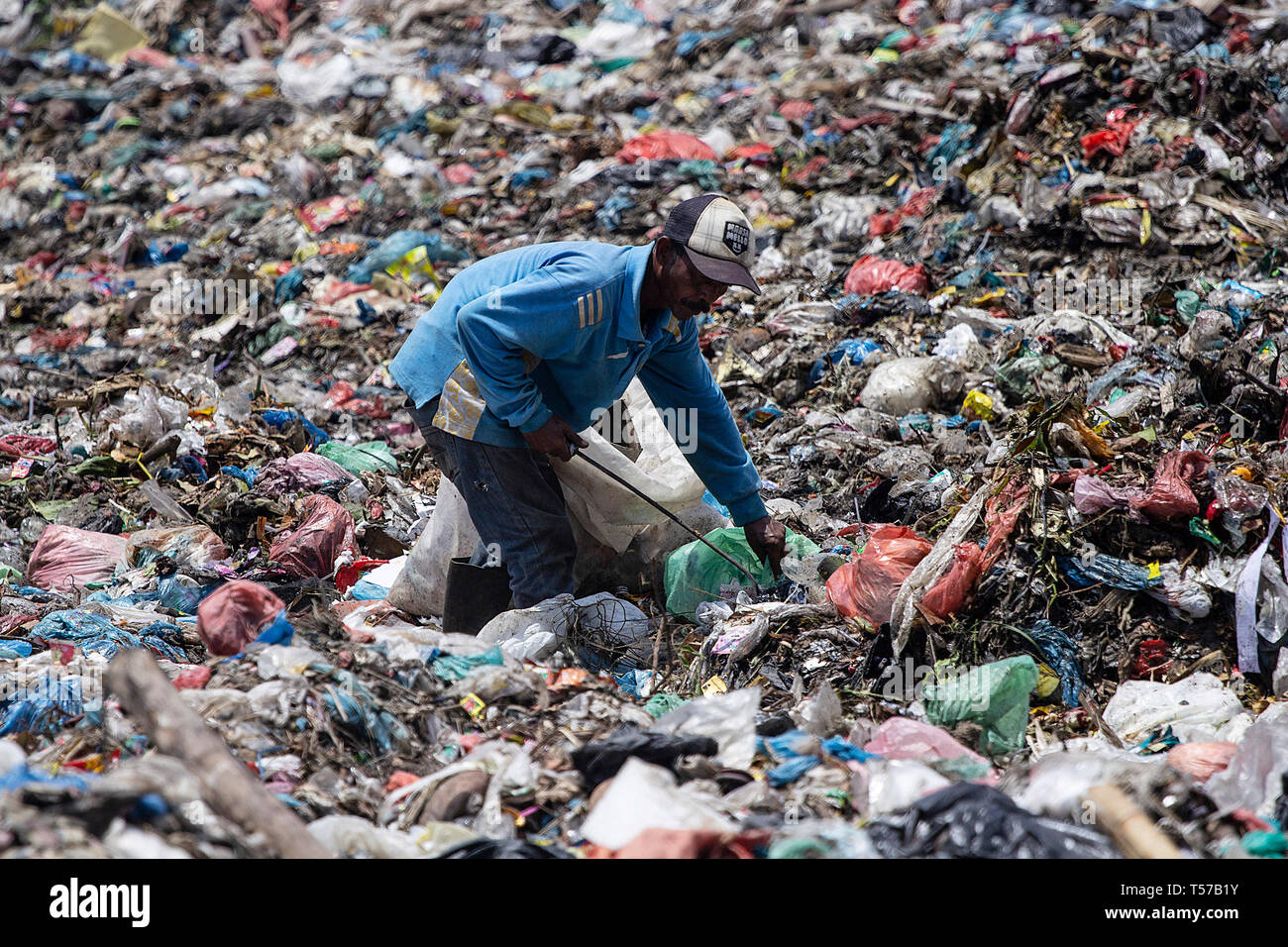 A scavenger seen looking for plastic bottle trash at a garbage dump in ...