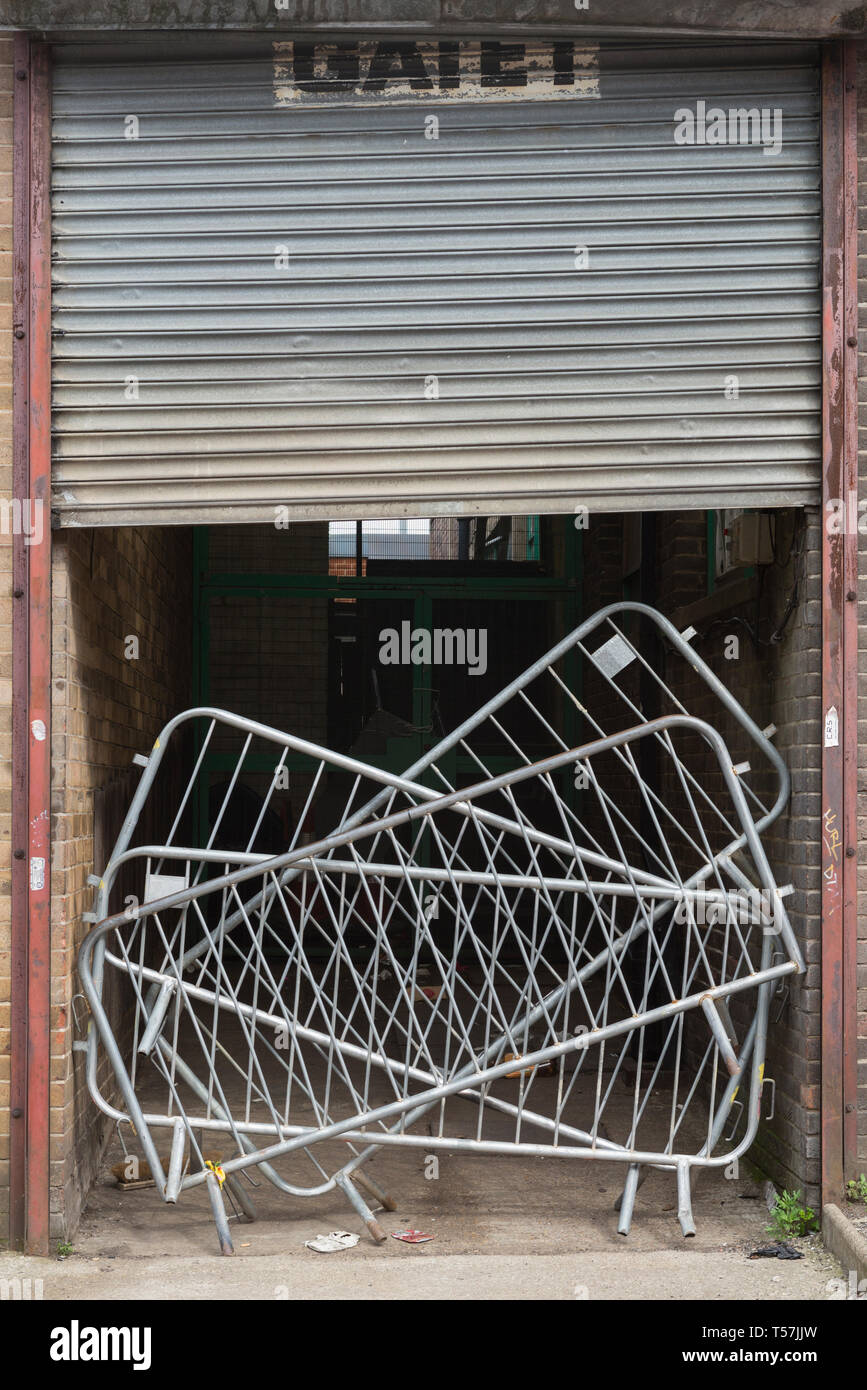 Stacked metal barriers across factory entrance with half closed metal ...
