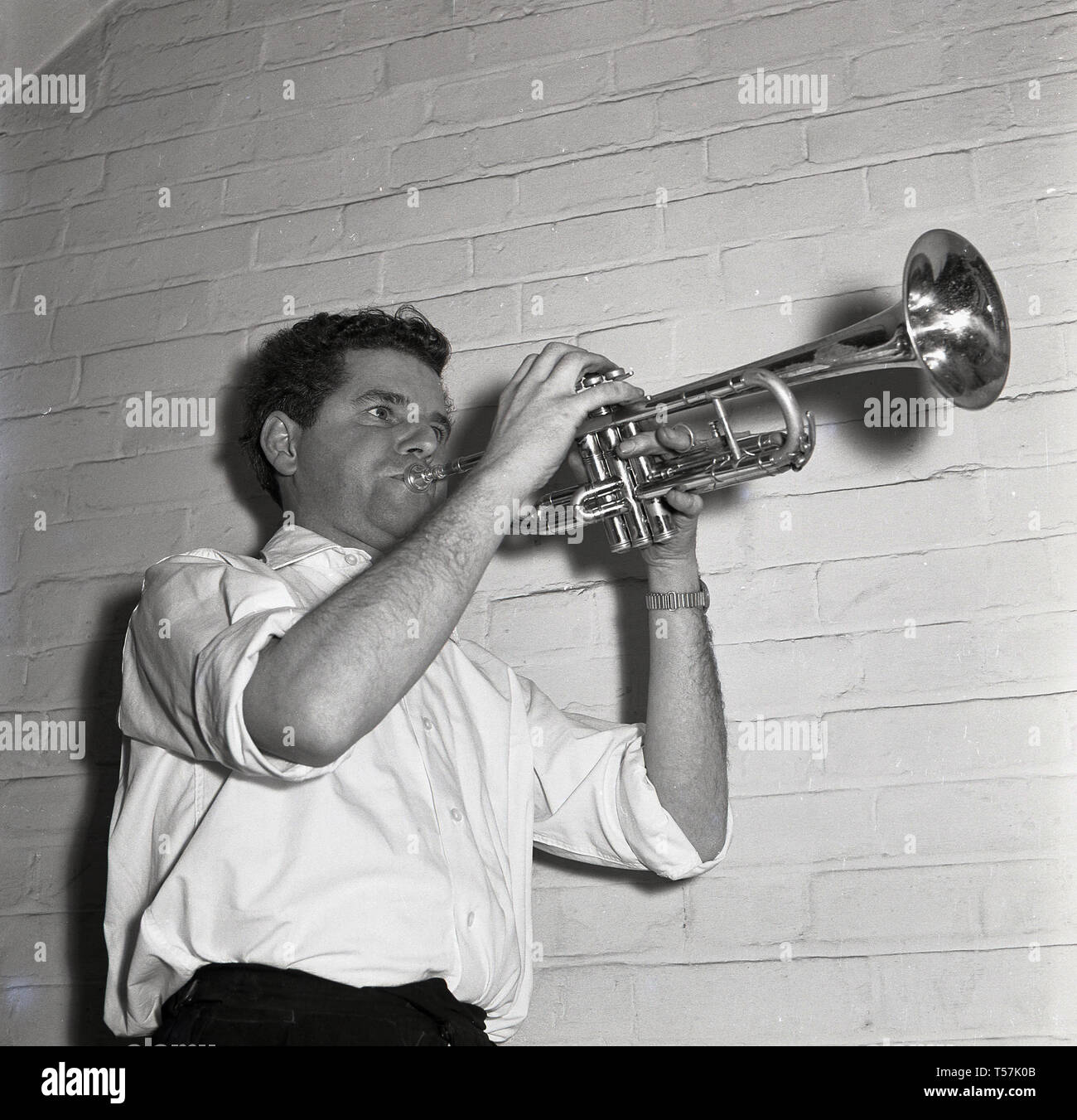 1960s, historical, inside a corridor, a man playing a trumpet, England ...