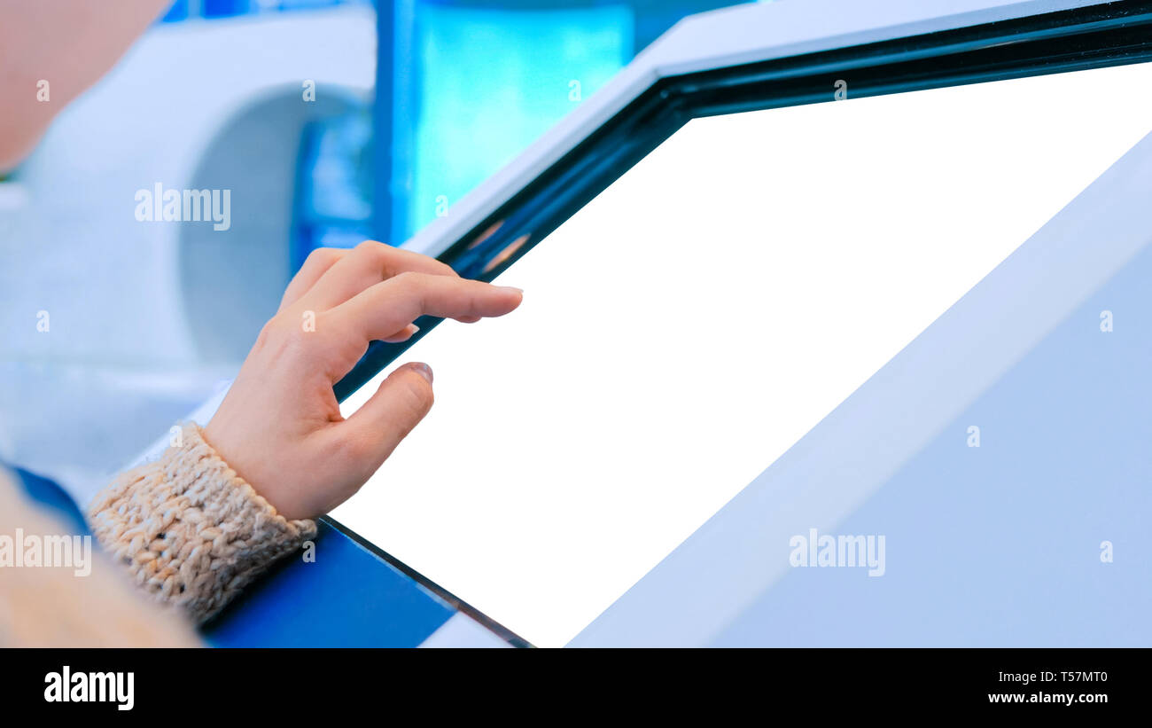 Woman using interactive digital informational kiosk with touchscreen ...