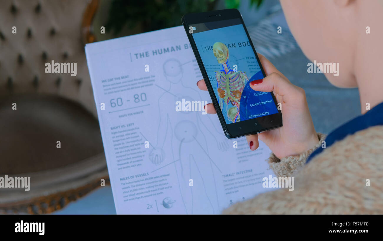 MOSCOW, RUSSIA - AUGUST 10, 2018. Woman using smartphone with augmented ...