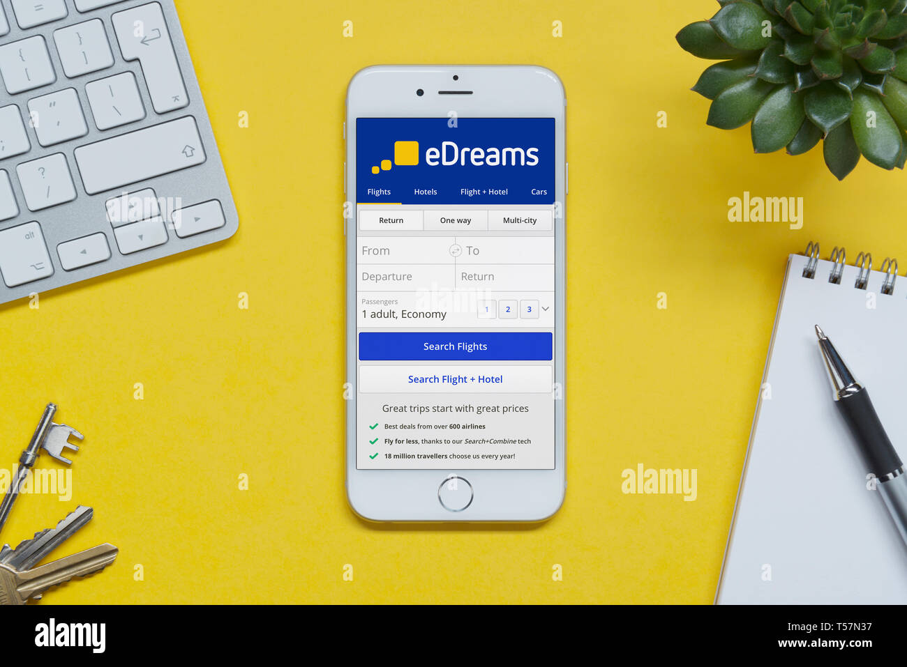 An iPhone showing the eDreams website rests on a yellow background ...