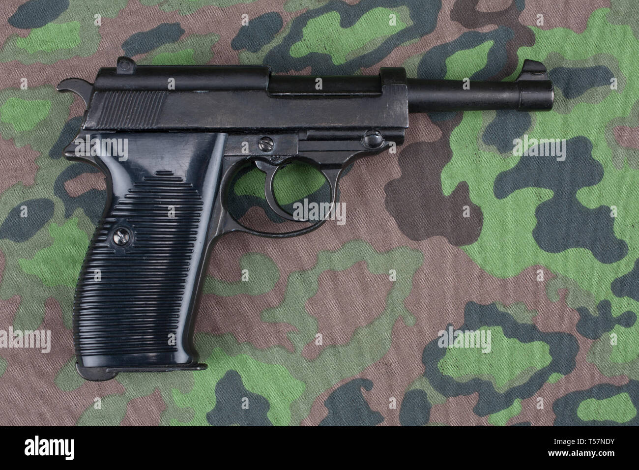 WWII era nazi german army 9 mm semi-automatic pistol on camouflaged ...