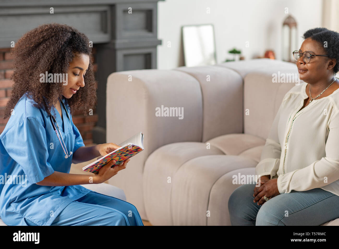 African-American nurse checking medical record of aged lady Stock Photo ...