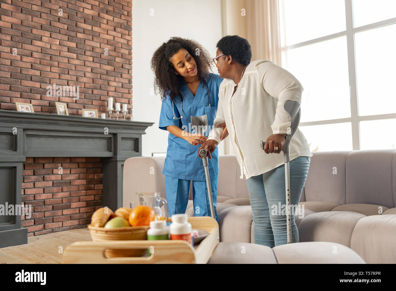 Assisting medical attendant of hospital helping woman to walk Stock ...
