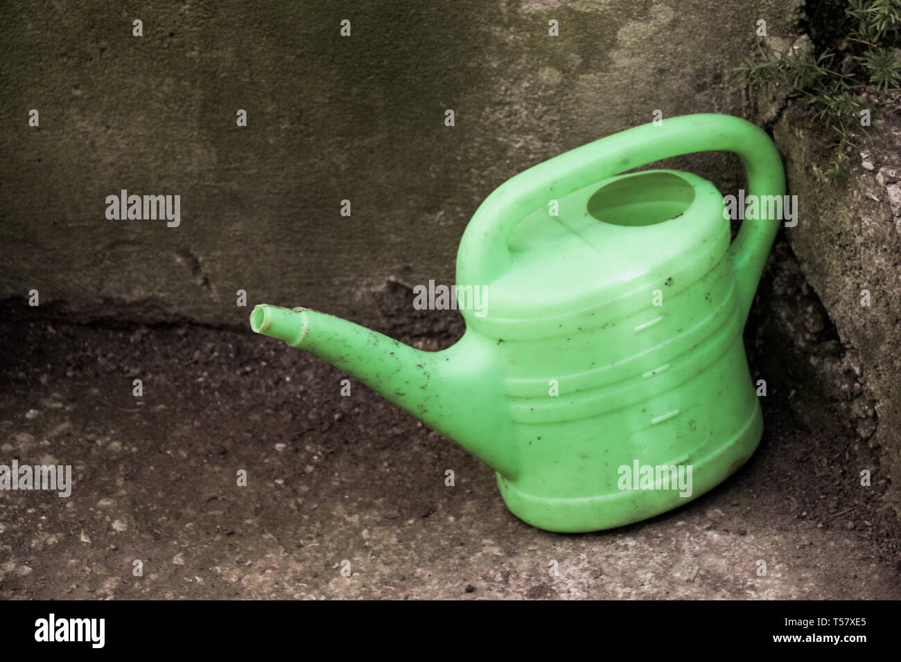 Little red color watering can on green sand Stock Photo - Alamy
