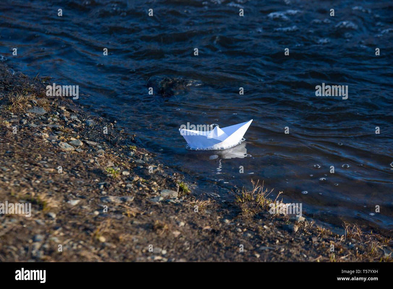 White paper toy boat on blue water near the shore Stock Photo - Alamy