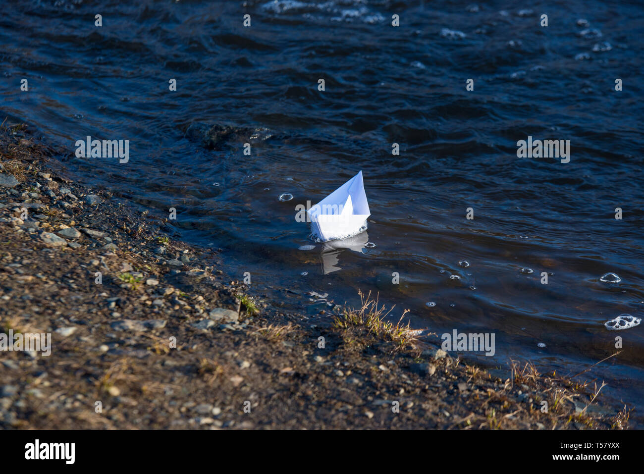White paper toy boat on blue water near the shore Stock Photo - Alamy