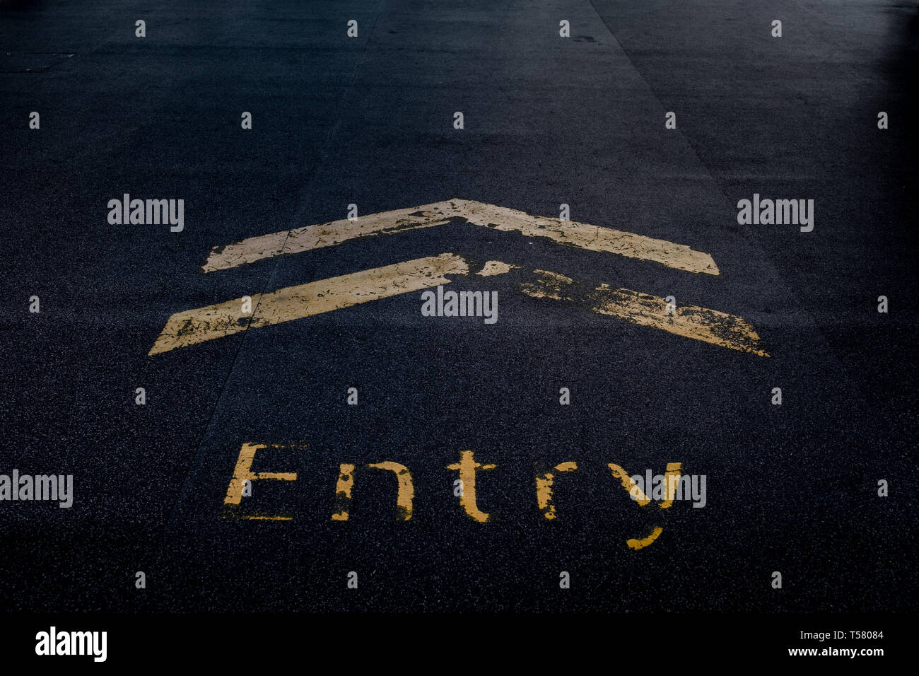 Yellow entry arrows on the ground Stock Photo - Alamy