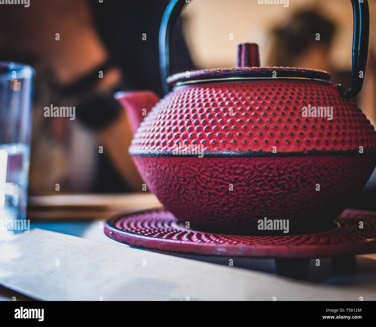Red coloured, cast iron tea pot for serving infusion and herbal tea at ...