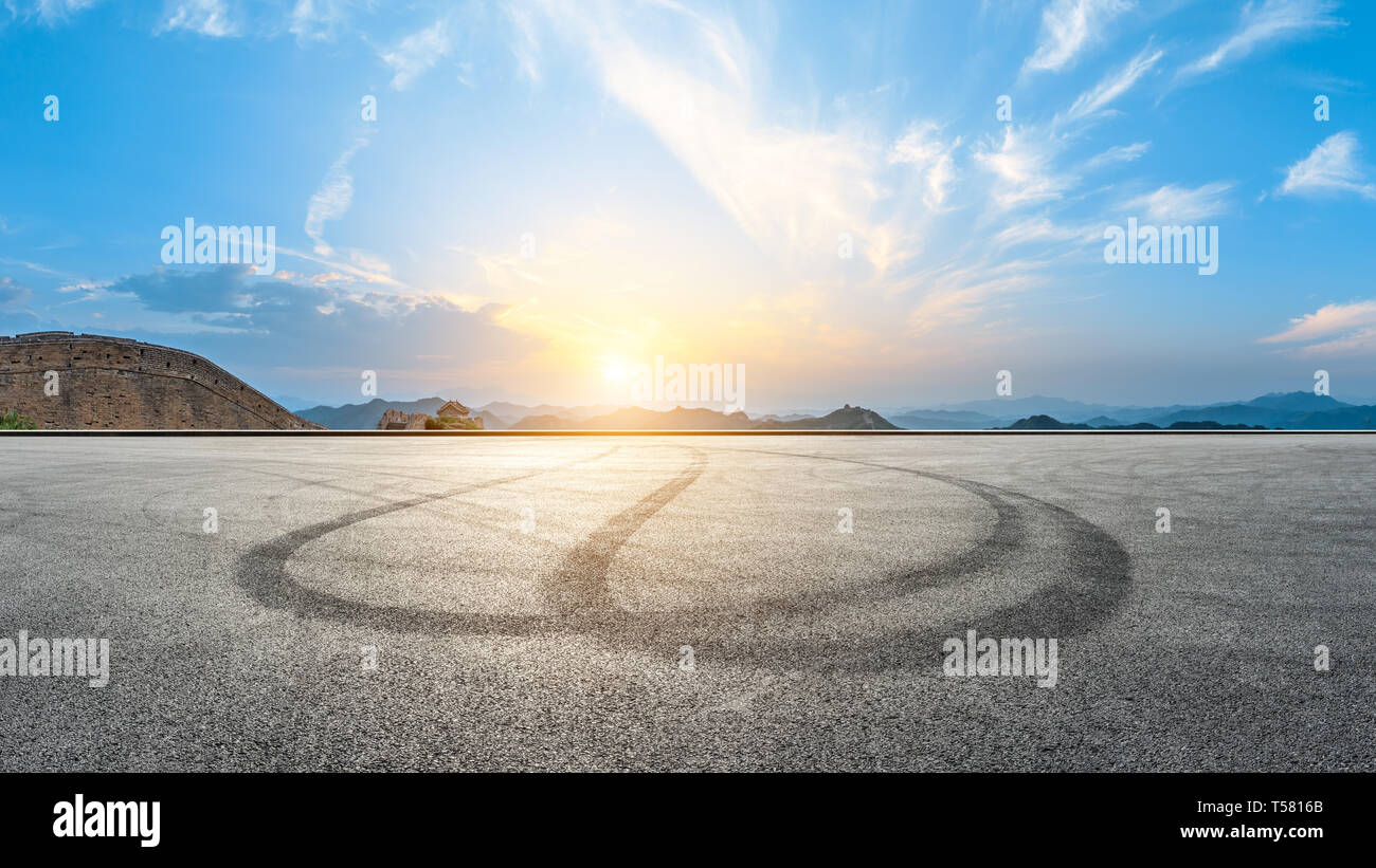 Asphalt race track ground and mountains with beautiful clouds at sunset ...