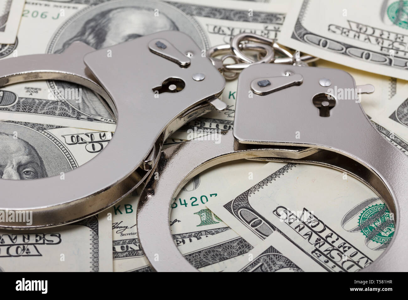 Handcuffs on money close up Stock Photo - Alamy