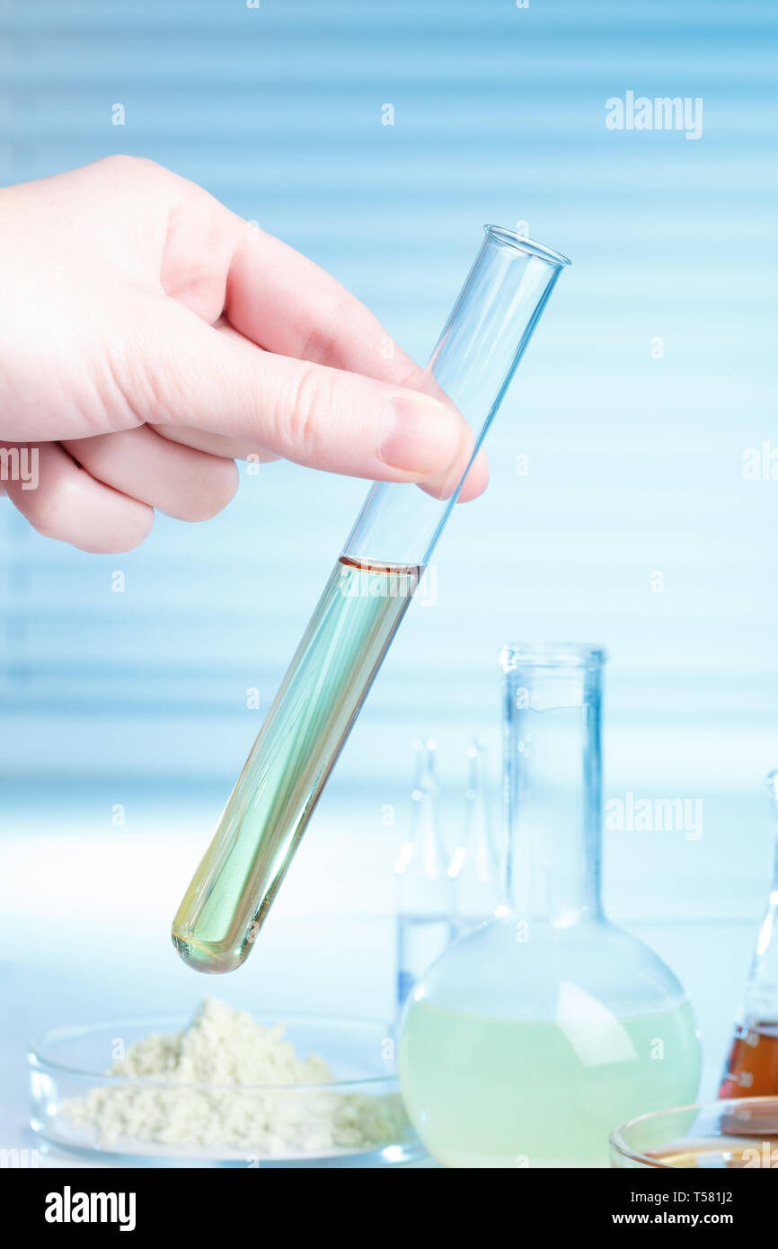 Hand with test tube in laboratory, medical or chemical research concept ...