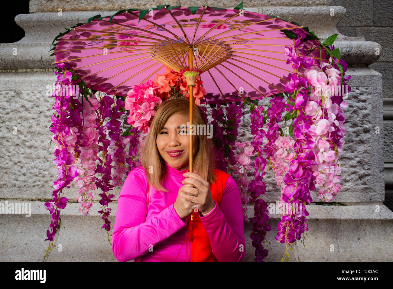 New York, NY - 21 April 2019. A woan with a parasol trimmed with ...