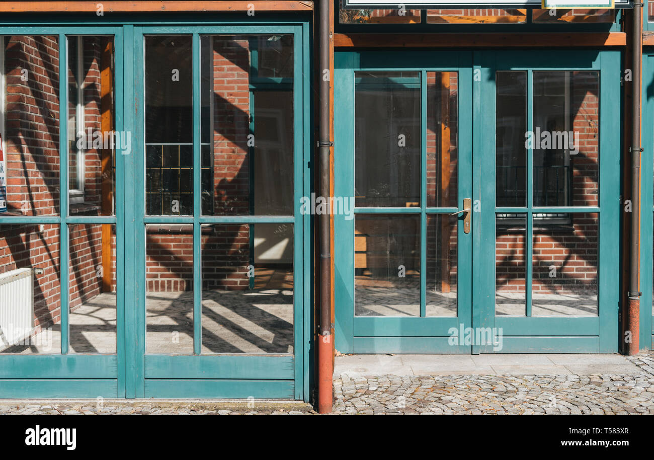 Glass windows and doors with turquoise frames at red bricked european ...