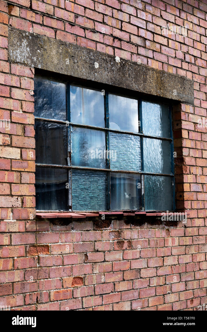 Dilapidated metal casement window frame on condemned derelict factory ...