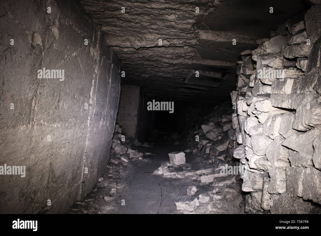 Old underground passage, dungeon, catacombs lined with stones and slabs ...