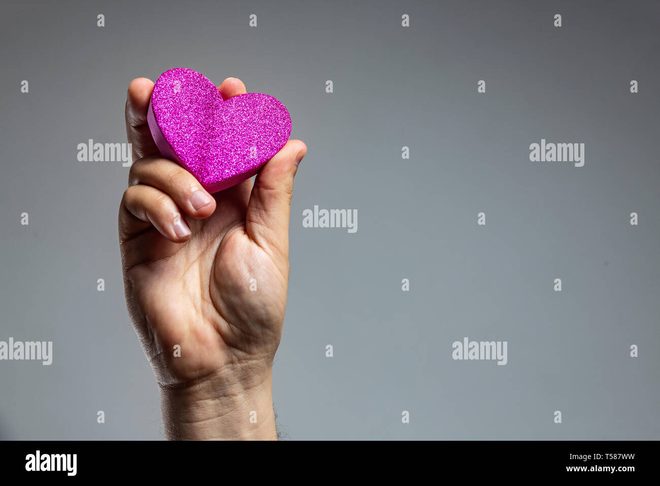 close up view of a hand holding a pink heart shape Stock Photo - Alamy