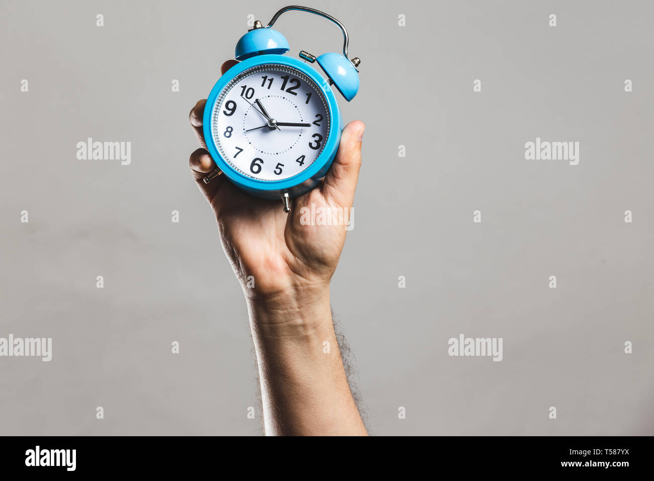 hand holding an alarm clock and raising it up Stock Photo - Alamy