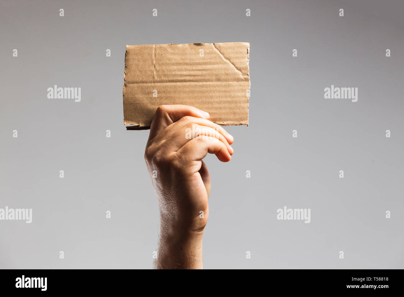 hand holding a cardboard against white background Stock Photo - Alamy