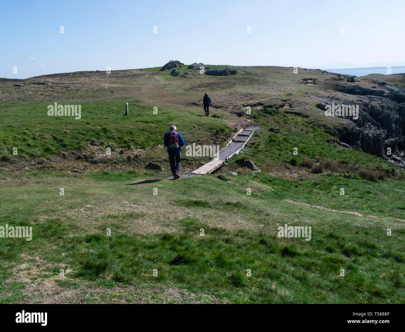 Man and woman walking the iconic Isle of Anglesey Coastal Path near ...