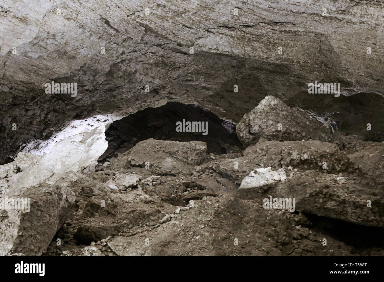 Half-filled with rock and clay natural cave. After collapse of ...