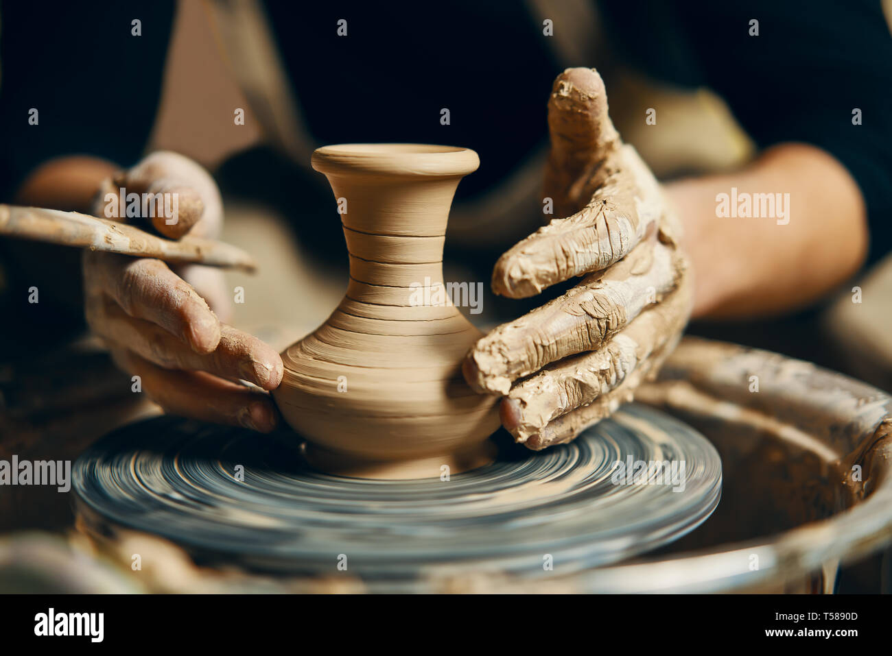 Potter modeling ceramic pot from clay on a potter's wheel. Workshop ...