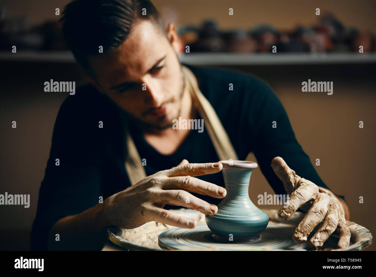 Potter modeling ceramic pot from clay on a potter's wheel. Workshop ...