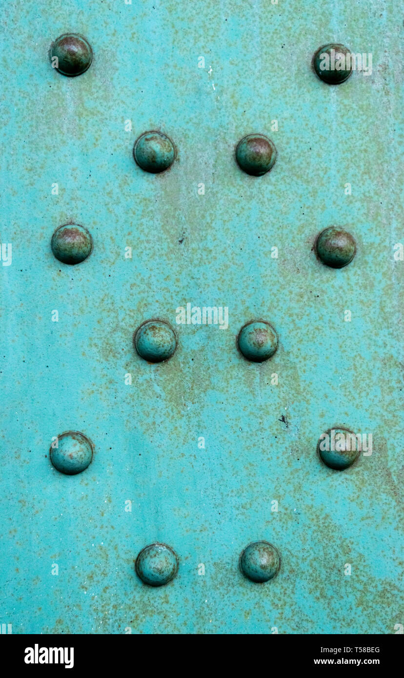 Steel rivets holding together an old weathered steel beam, with ...