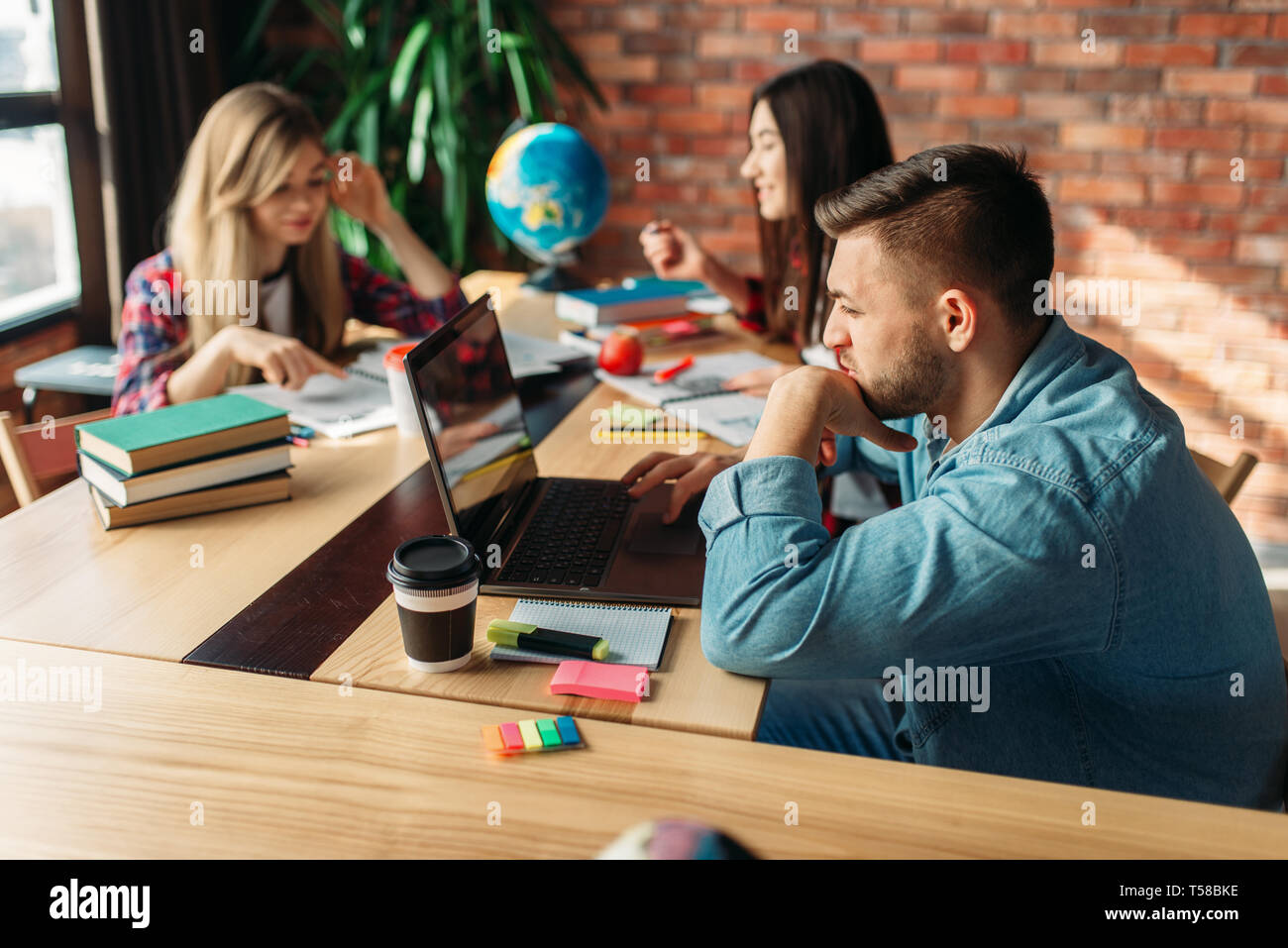 Group of students studying at the table together Stock Photo - Alamy