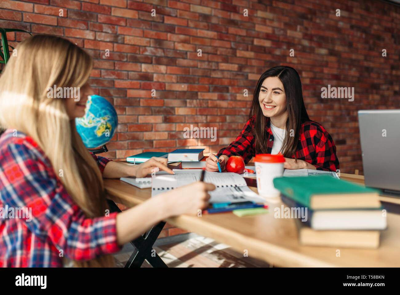 Two female students studying at the table together Stock Photo - Alamy
