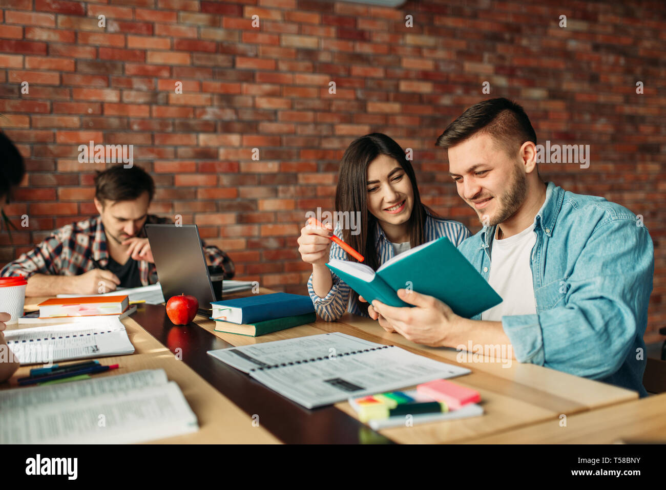 University students reading textbook together Stock Photo - Alamy