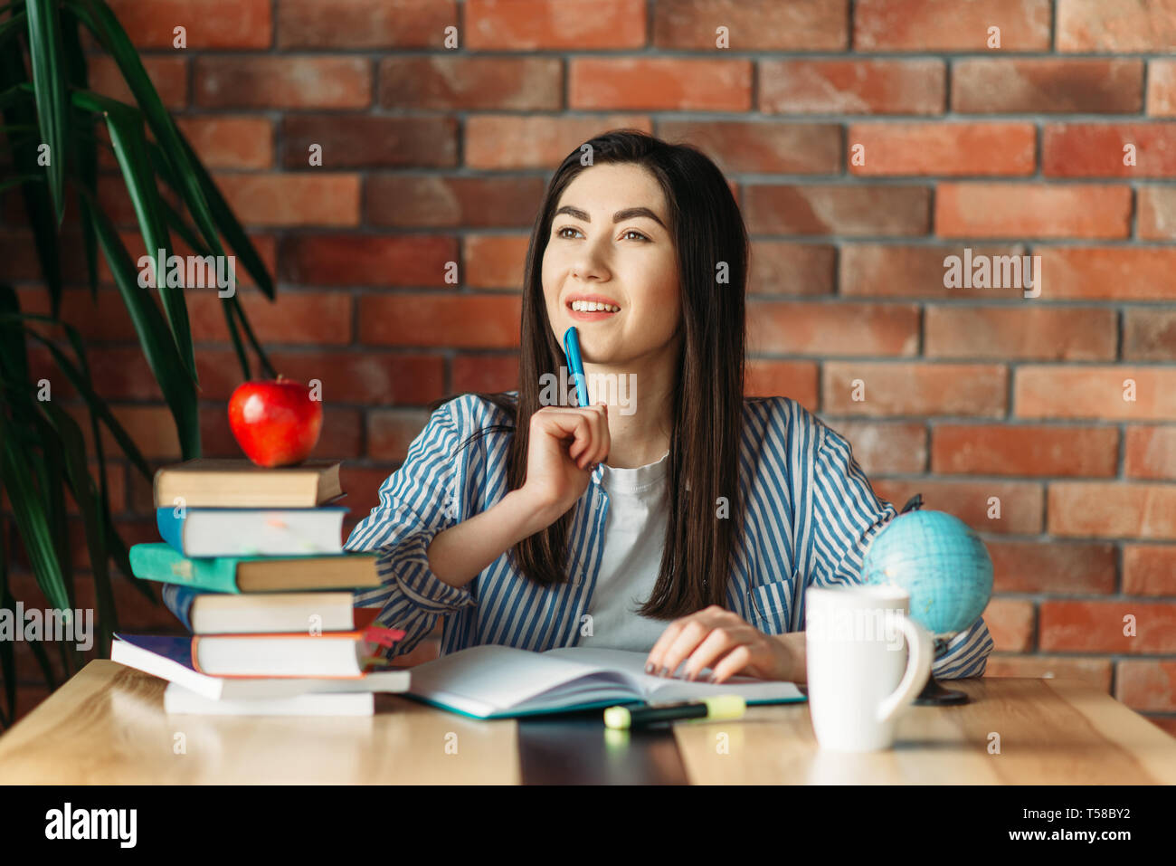 Female student sitting at the table with textbooks Stock Photo - Alamy