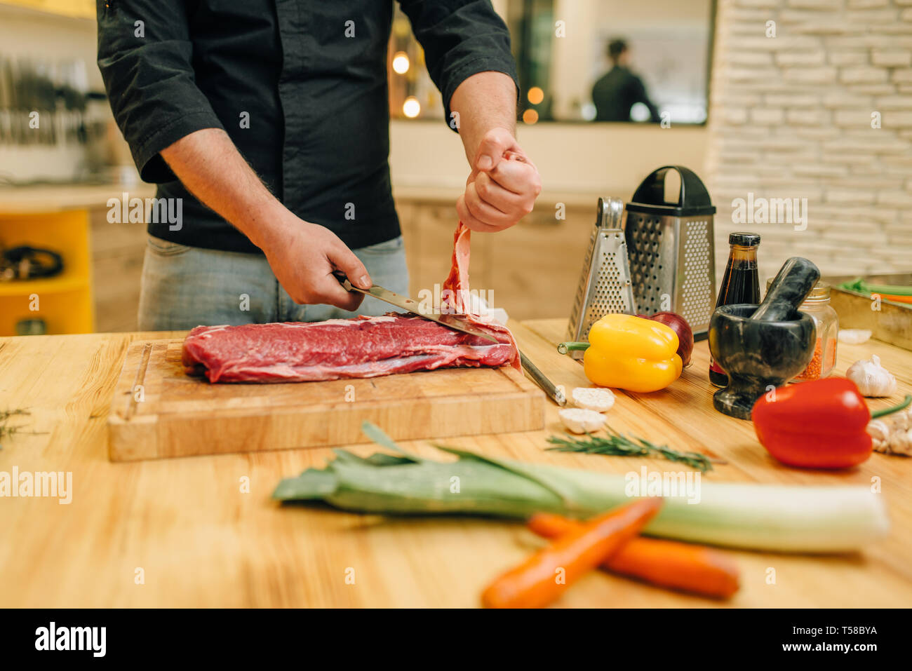Male butcher cutting meat on hi-res stock photography and images - Alamy