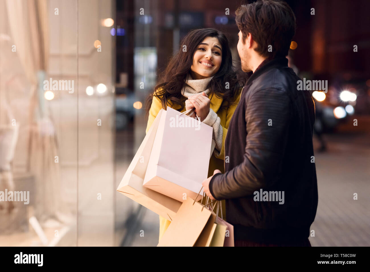Shopping together. Girl asking boyfriend to buy clothes Stock Photo - Alamy