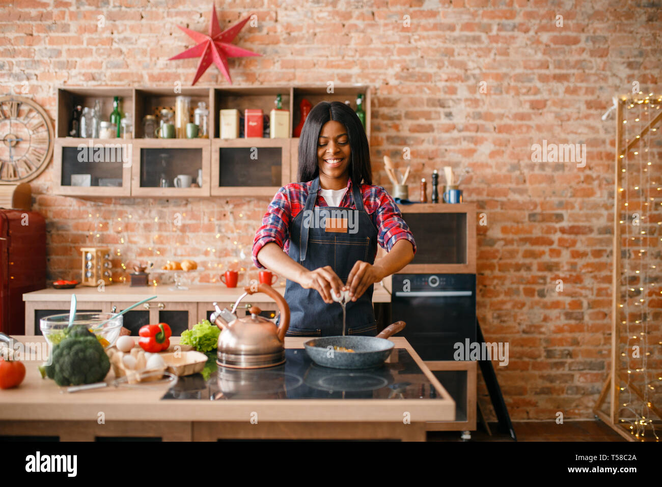Black female person cooking fried eggs on kitchen Stock Photo - Alamy
