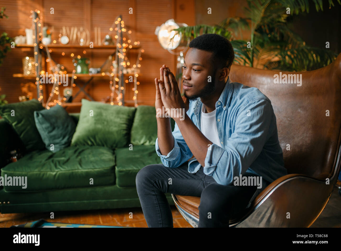 Black man sitting in a comfortable leather chair Stock Photo - Alamy