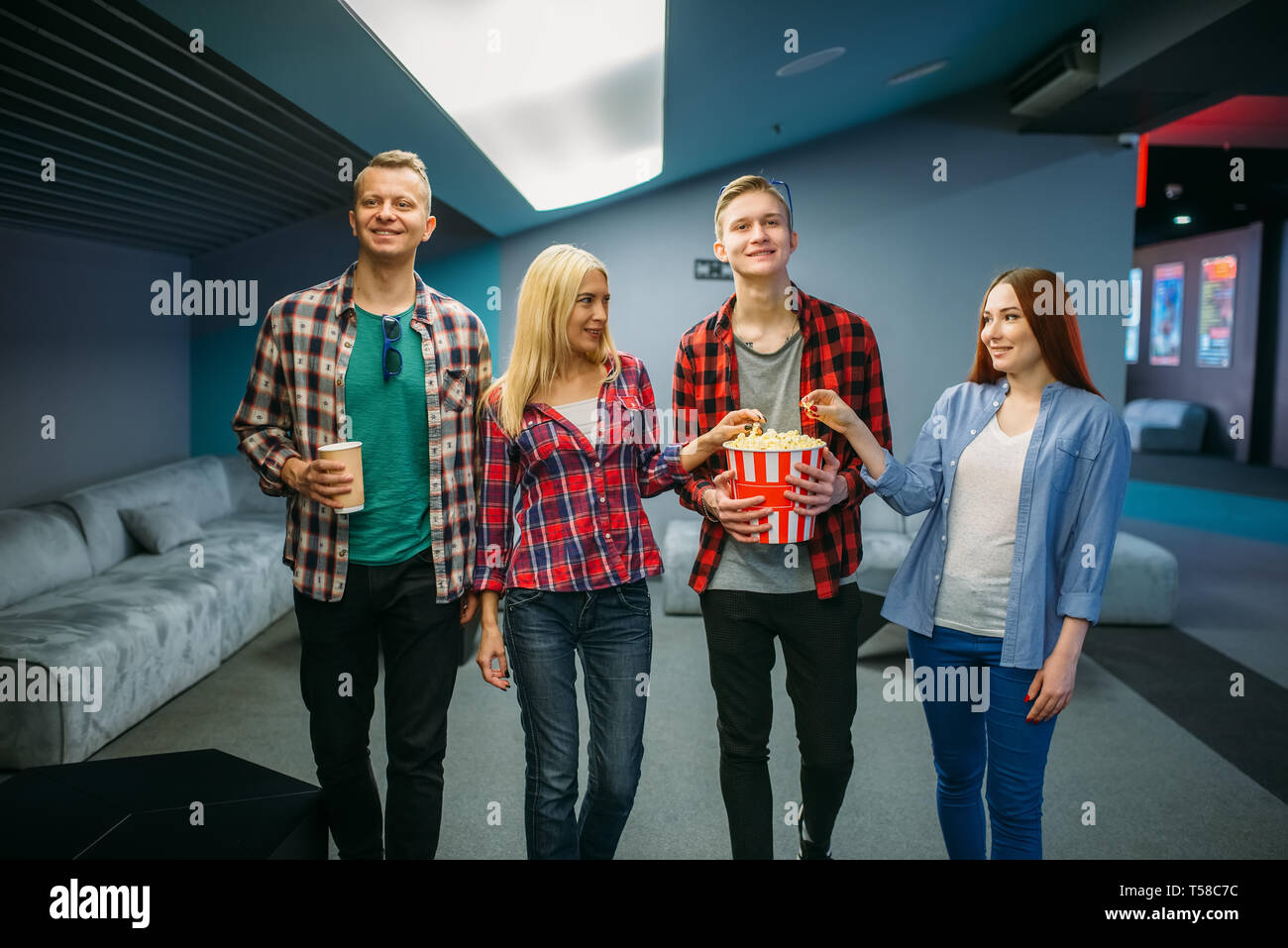 Group of friends with popcorn in cinema hall Stock Photo - Alamy