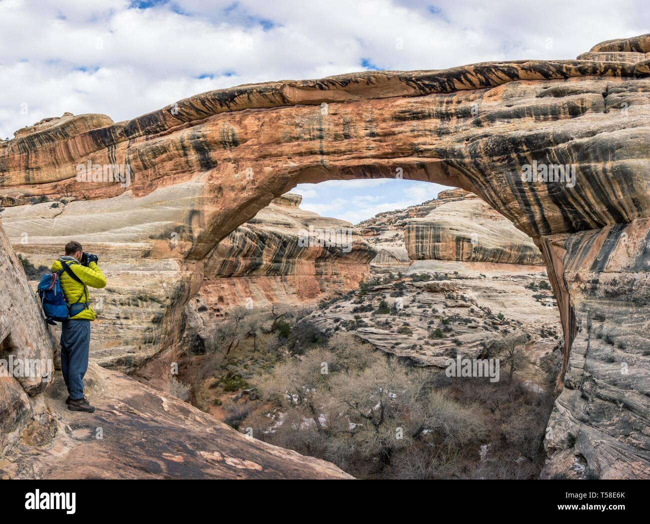 Tourist, hiker photographing rock arch, Sipapu Bridge, Natural Bridges ...