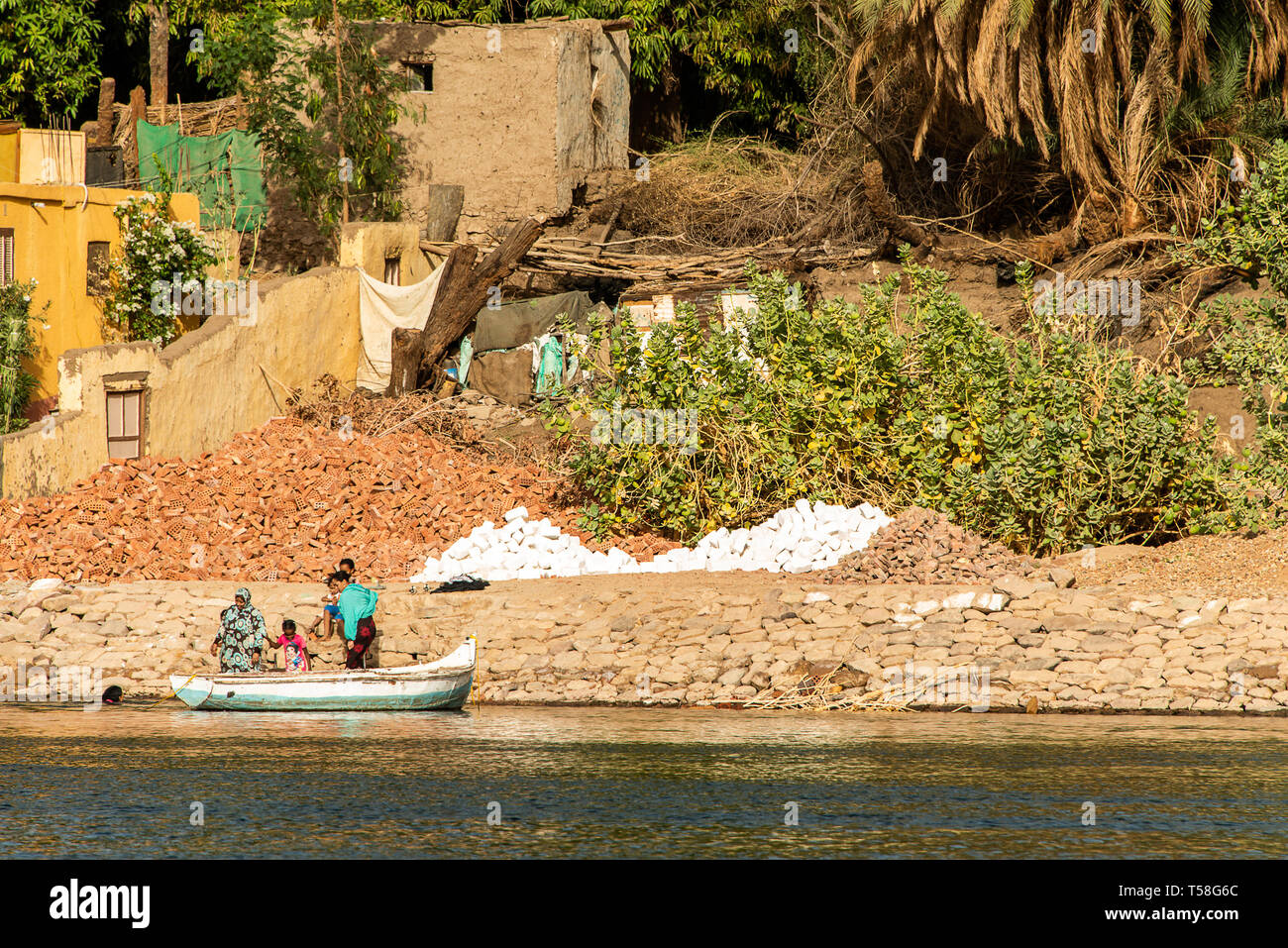 ASWAN, EGYPT 21.05.2018 Egyptian family working the nile river bank ...