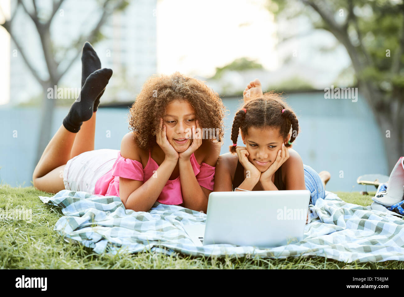 Content girls watching interesting video in park Stock Photo - Alamy