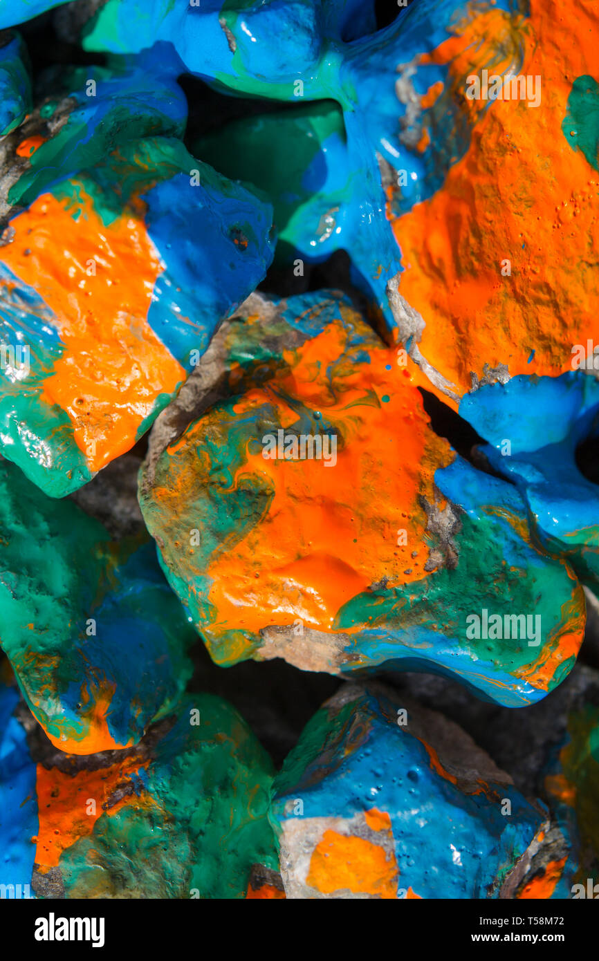 paint painted stones closeup. Painted in orange, blue, green color ...