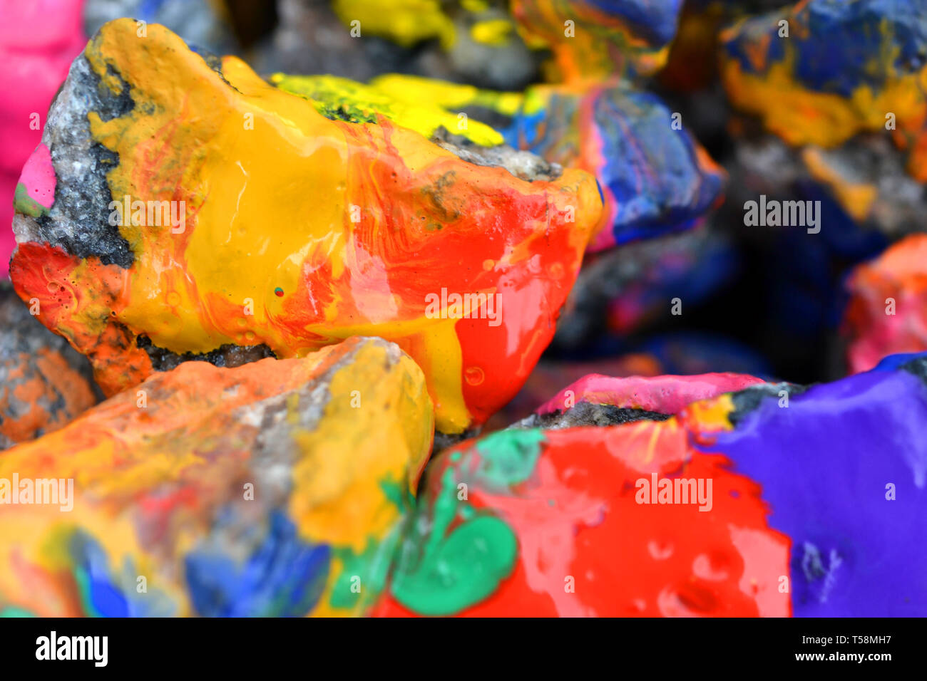 rocks covered with colorful paint close-up. Stones in the paint with ...