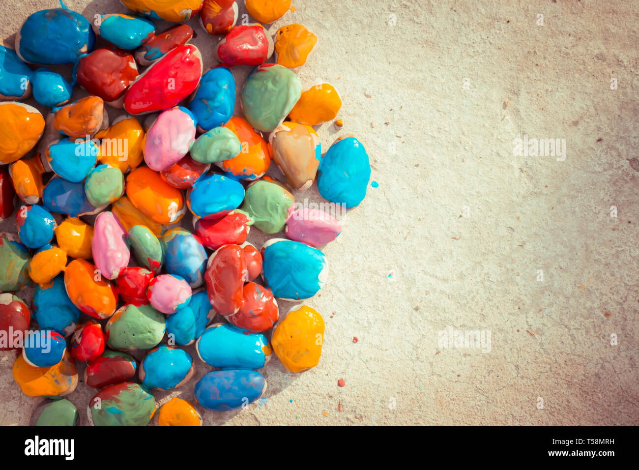 Colored stones colored paints in different colors lie on a flat surface ...
