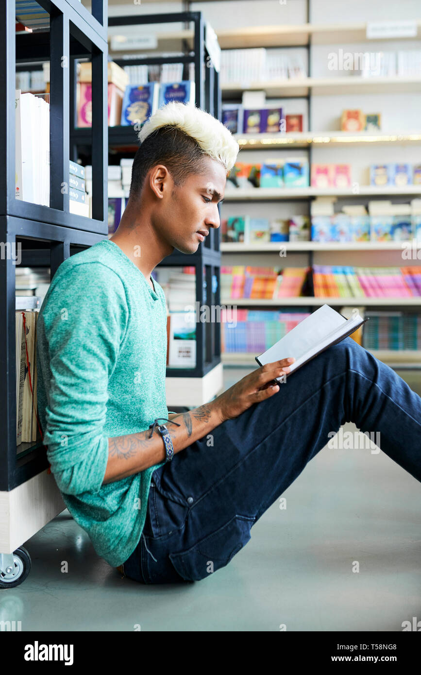 Black student reading interesting book Stock Photo - Alamy