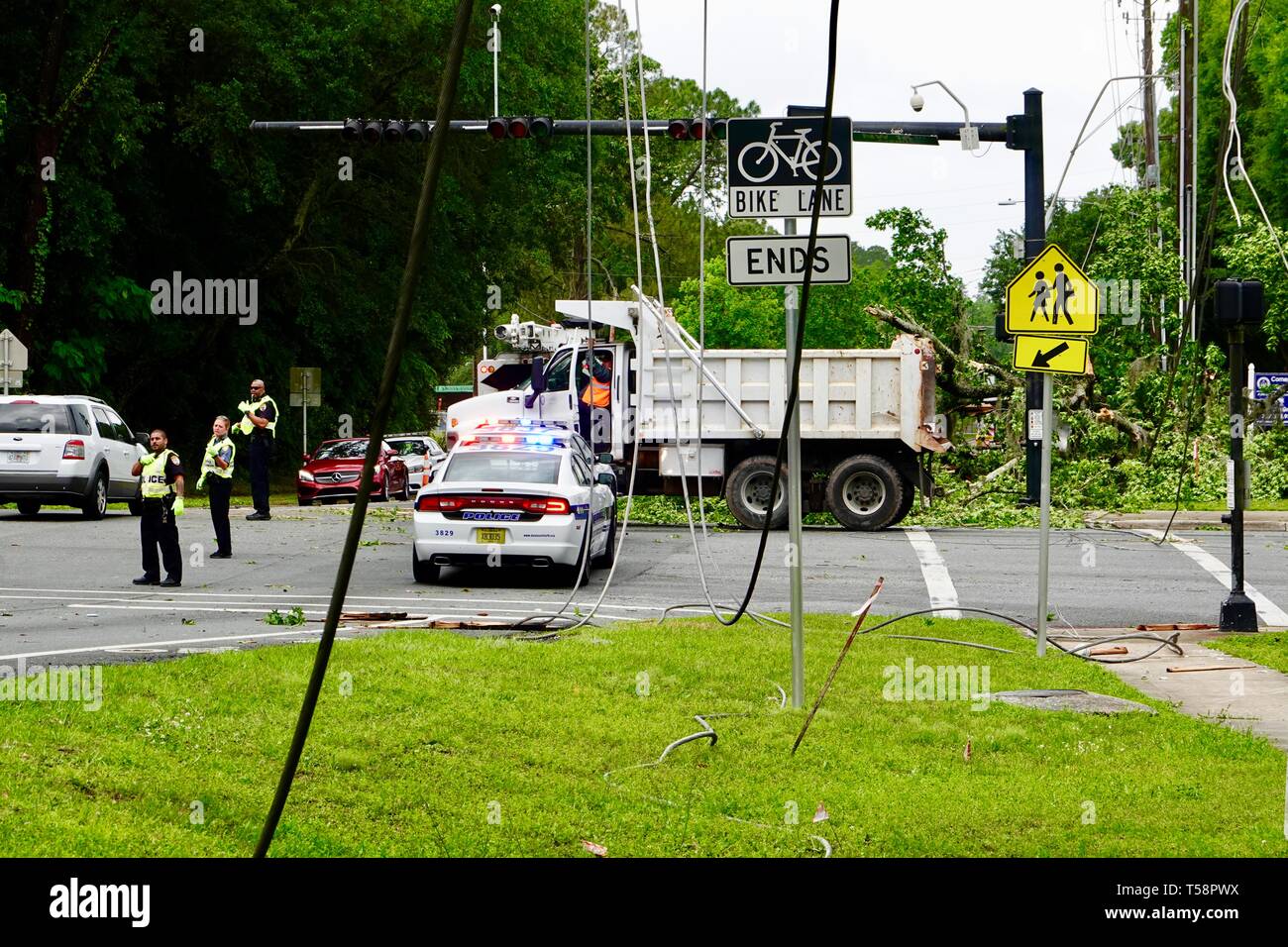 Aftermath of storm, wind, damage with police and utility crews cleaning ...