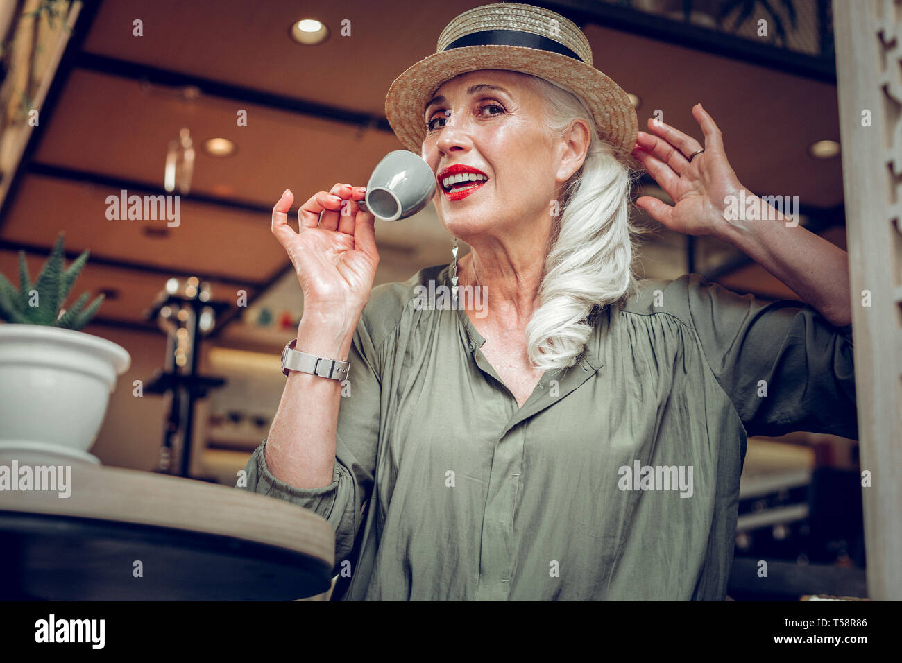 Low angle of a nice positive woman drinking coffee Stock Photo - Alamy
